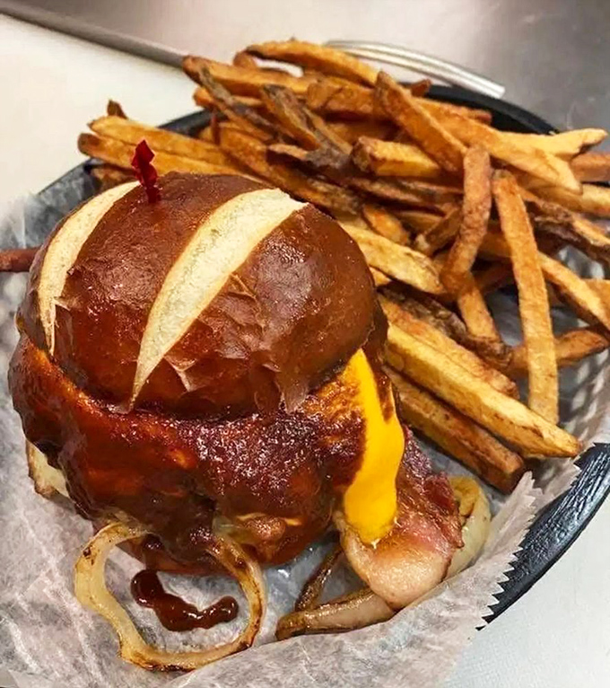 This isn't just a burger; it's architectural genius on a pretzel bun with cheese cascading down the sides like a delicious golden waterfall.