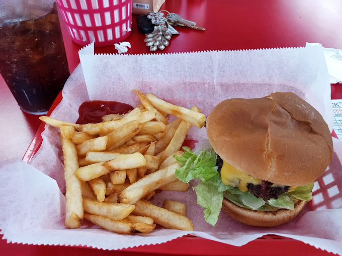 The hero of our story – a perfectly proportioned cheeseburger with golden fries that proves simplicity, when done right, is the ultimate sophistication.