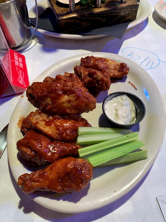 Buffalo wings that make you question why we ever invented forks. That celery stick is just there to make you feel virtuous between bites.