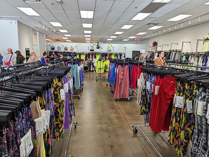 A rainbow of possibilities awaits inside this outlet store. The methodical organization of colors makes finding your size a surprisingly pleasant treasure hunt.