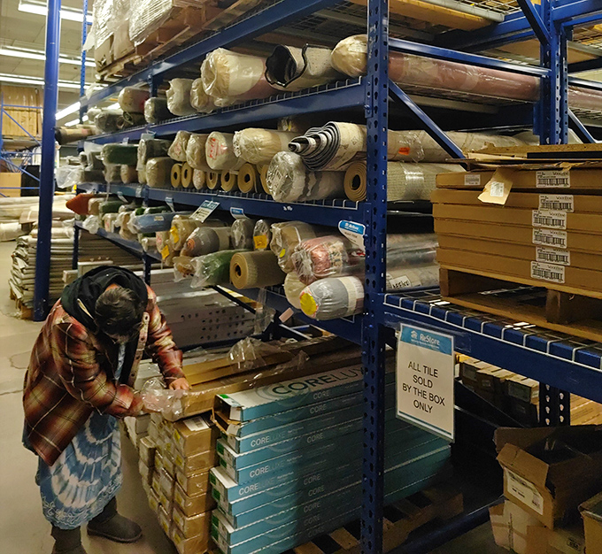 Treasure hunting requires patience and a keen eye. This shopper examines flooring materials with the focus of a detective on a hot case.