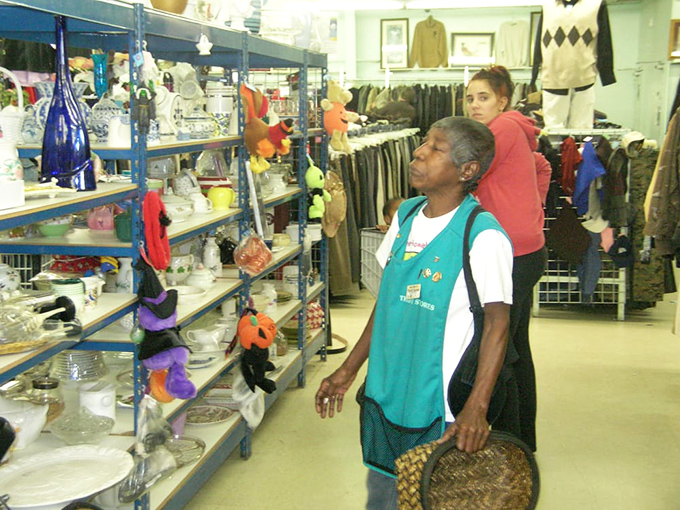 The true thrift store experience: customers browsing with purpose, basket in hand, hunting for that perfect something nobody else will have.
