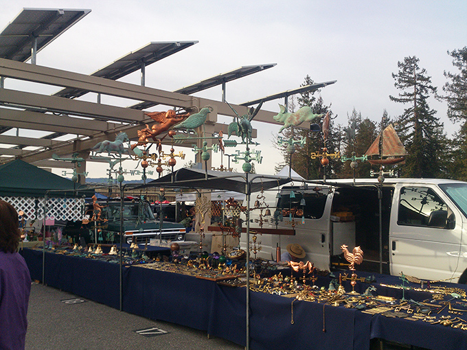 Whimsical weathervanes and garden art create a colorful skyline above the vendor tables. Your garden called&mdash;it's feeling a bit underdressed.
