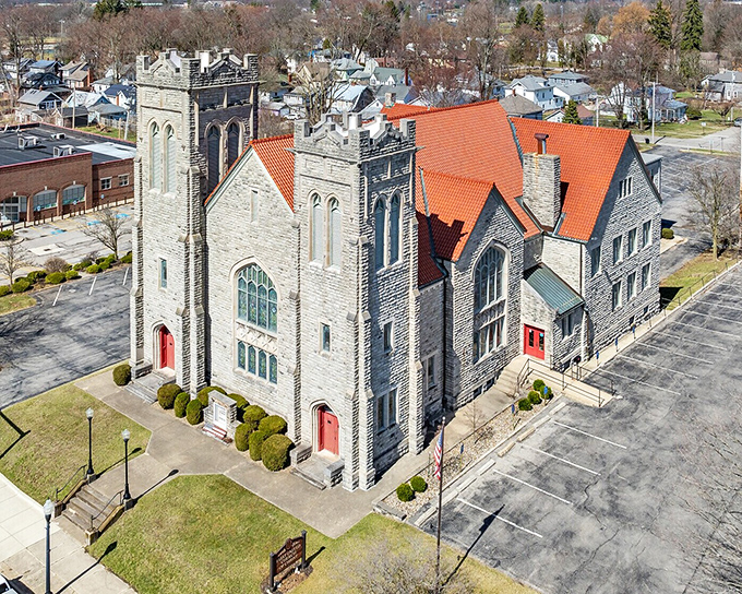 This magnificent stone church stands as an architectural marvel, its Gothic details and vibrant red roof a testament to craftsmanship rarely seen today.