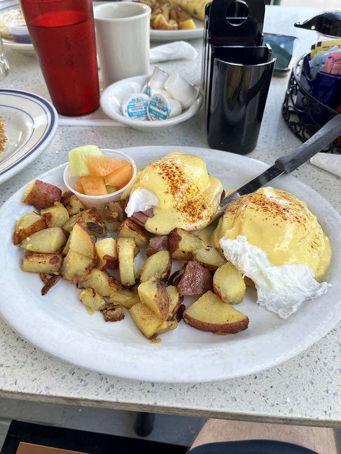 The star of the show: Eggs Benedict with hollandaise so velvety it should be illegal, accompanied by home fries that could start their own fan club.
