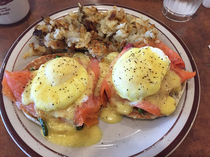 Eggs Benedict done right – perfectly poached eggs draped in hollandaise atop salmon, creating a breakfast masterpiece that belongs in the Louvre of morning meals.