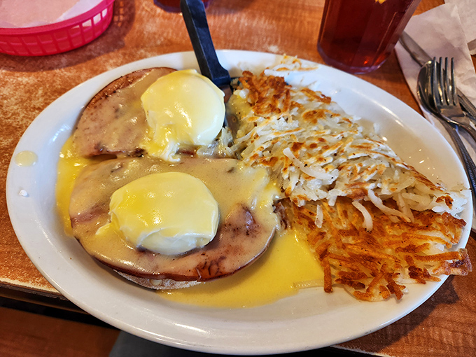 Eggs Benedict with a side of hash browns that look like they've been kissed by the sun. Breakfast romance at its finest.
