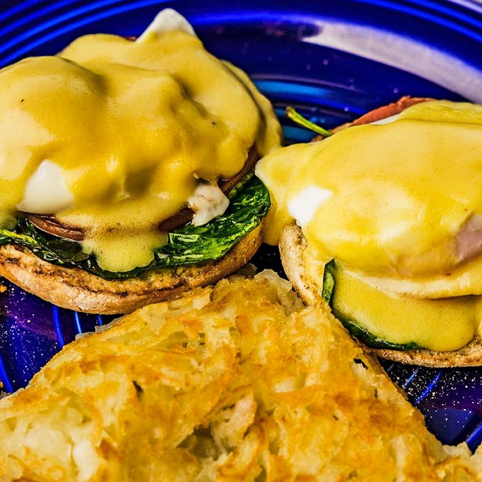 Eggs Benedict reimagined with vibrant greens and hollandaise so rich it should have its own tax bracket.
