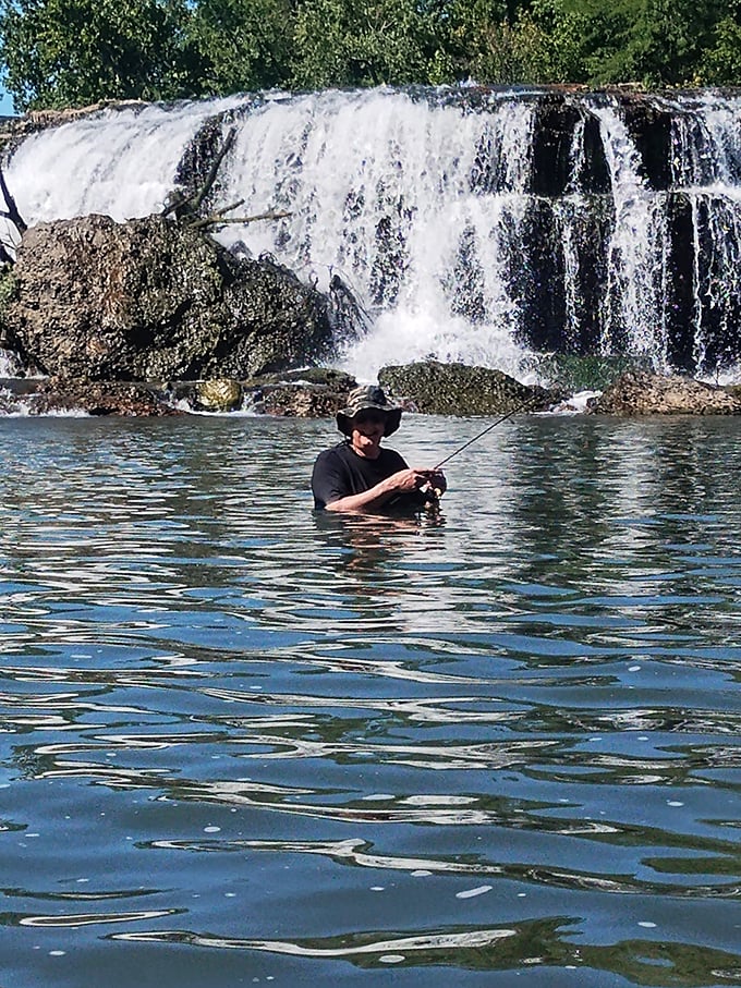 Fishing below the falls&mdash;where the angler's patience meets nature's perfect soundtrack. The fish are just a bonus.