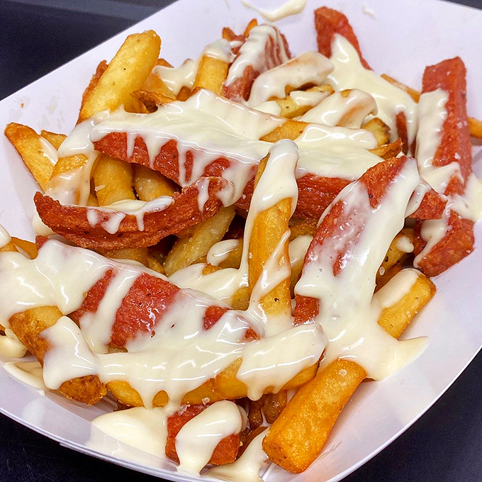 Behold the pinnacle of indulgence: crispy fries draped in cheese sauce that flows like a golden waterfall of deliciousness.