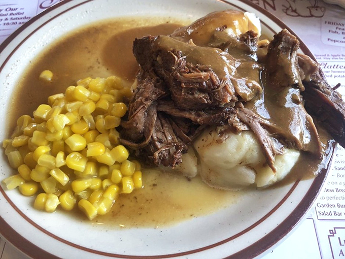 Pot roast nirvana! Tender beef swimming in gravy alongside those legendary mashed potatoes and sweet corn&mdash;a holy trinity of comfort that speaks directly to your soul.