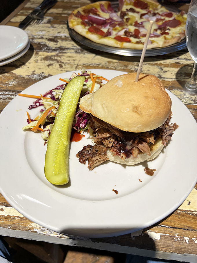 This pulled pork sandwich isn't messing around&mdash;it's bringing the smoke, the tang, and that pickle spear standing guard like a delicious sentinel.