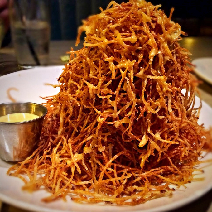 These aren't just fries; they're a golden tower of crispy potato perfection that demands to be photographed before the inevitable demolition begins.