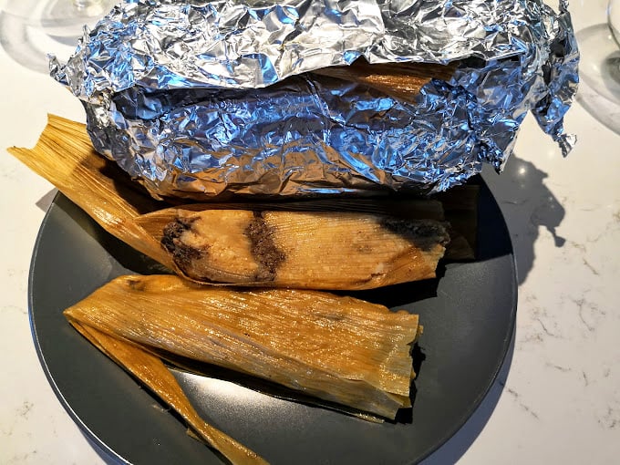 Fresh tamales wrapped in corn husks represent generations of traditional cooking methods passed down through Mexican families.