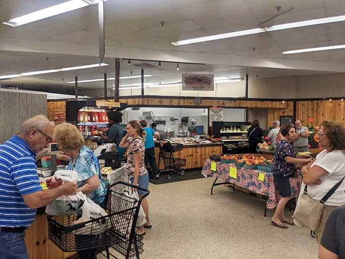 Busy shoppers navigate aisles filled with fresh produce, creating a community marketplace atmosphere that's refreshingly authentic.