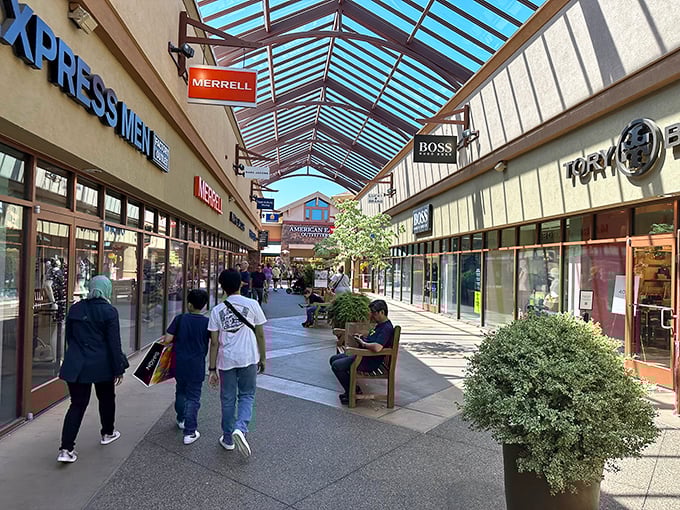 Covered walkways lined with potted plants and benches create shopping sanctuaries where weary bargain hunters can regroup before their next retail adventure.