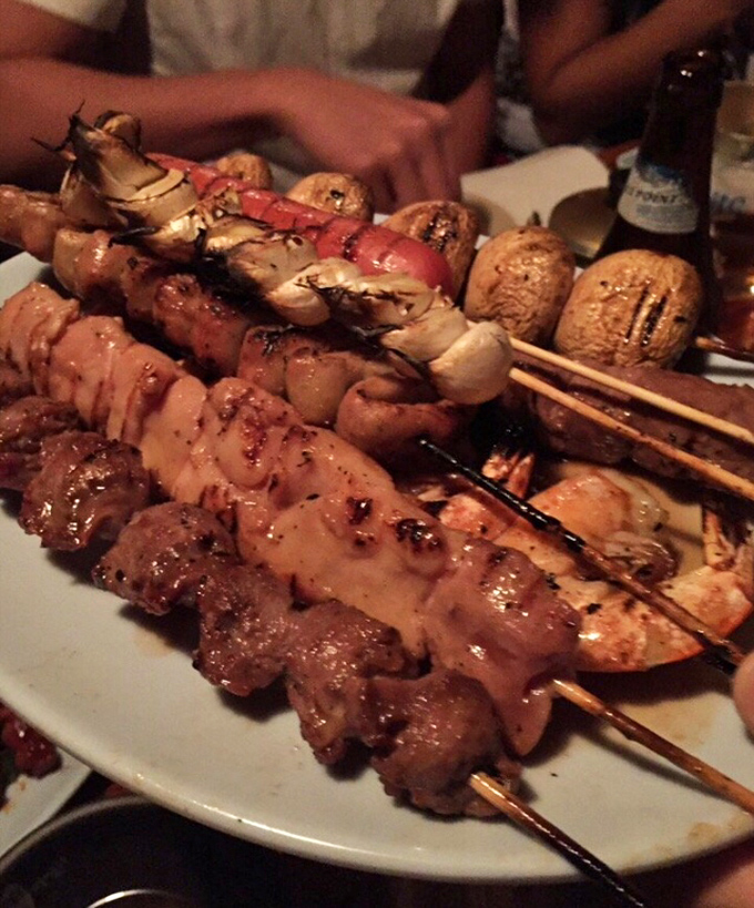A plate of skewers that proves heaven exists on a stick. The perfect harmony of meat, seafood, and vegetables, each morsel kissed by fire and seasoned with expertise.