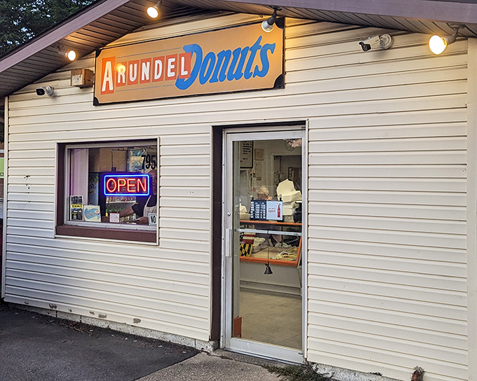 Arundel Donuts' humble white building with its cheerful sign promises simple pleasures done right. Donut perfection awaits!