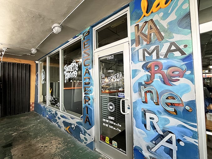 The vibrant blue "Pescaderia" sign promises seafood treasures within. La Camaronera's modest entrance hides Miami's most authentic fish sandwich experience.