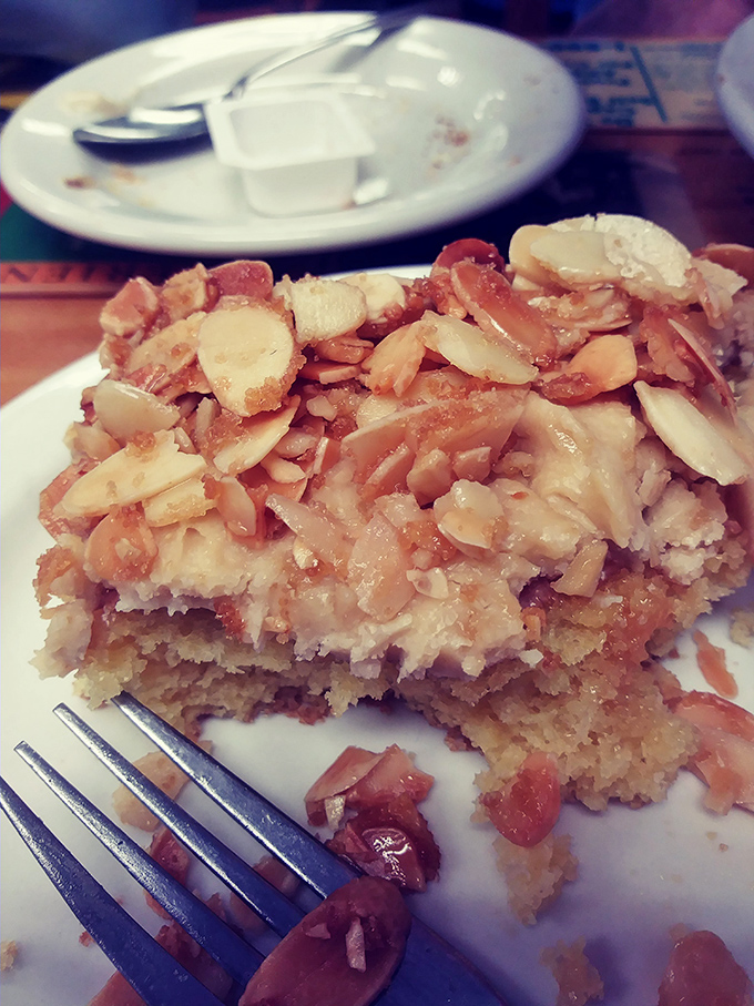 Heaven has layers, and they all involve toasted almonds atop what appears to be a masterclass in crust-to-filling ratio. Fork optional, napkin mandatory.