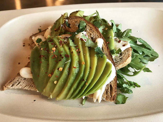 Avocado toast done right: perfectly ripe, artfully fanned, and sprinkled with red pepper flakes for that "I care about the details" touch.