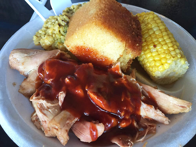 Pulled chicken bathed in that signature sauce, with cornbread and corn on the cob—a Southern trifecta that makes taste buds stand up and salute.