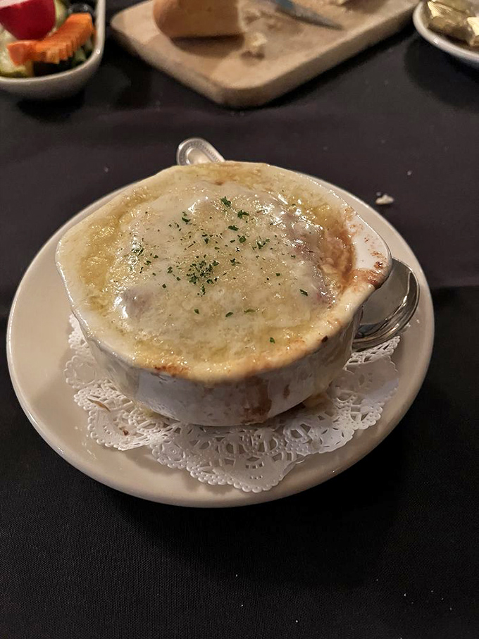 This isn't just French onion soup; it's a cheese-capped cauldron of comfort that requires a moment of silent appreciation before diving in.