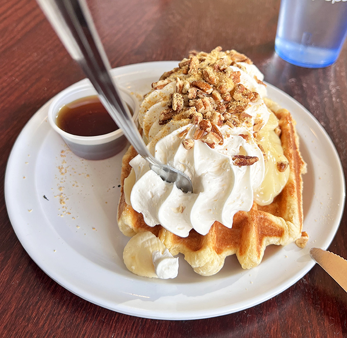 The Banana Pudding Waffle arrives like a cloud of breakfast joy &ndash; crisp Li&egrave;ge waffle, creamy topping, and candied pecans that dance across your taste buds.