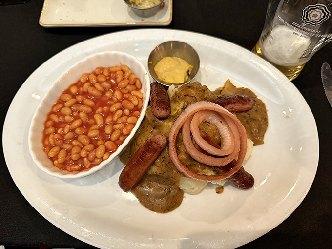 Bangers and mash with proper onion gravy and baked beans. This plate screams "British comfort food" louder than the Queen saying "one is not amused."