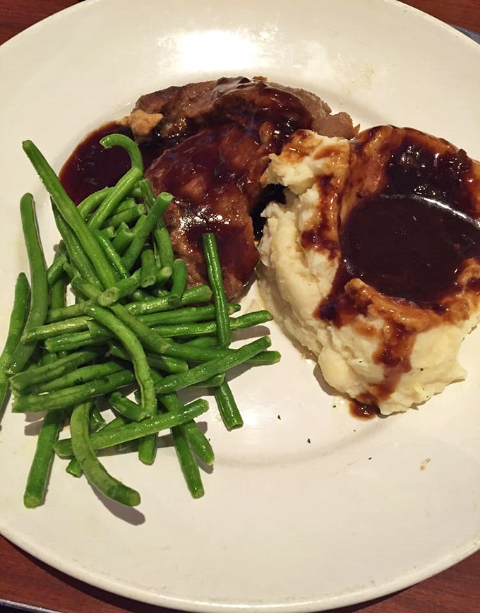 Meat so tender it practically files for divorce from the bone. Those mashed potatoes aren't just a side dish—they're a gravy swimming pool for champions.