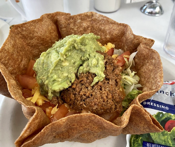 A tostada shell transformed into an edible art piece, where guacamole serves as the creamy centerpiece of this crunchy masterpiece.