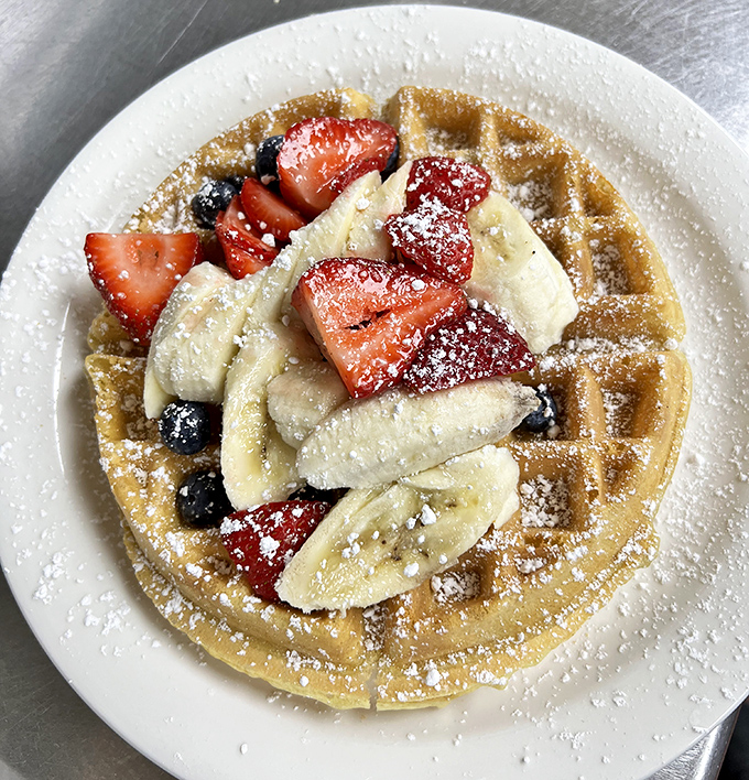 A Belgian waffle that serves as both breakfast and art canvas, topped with fresh fruit that almost&mdash;almost&mdash;makes you feel virtuous about dessert for breakfast.