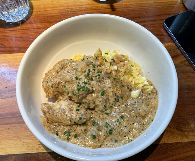 Comfort food reaches its final form in this bowl of biscuits and gravy. The chives aren't just garnish&mdash;they're little green confetti celebrating this masterpiece of morning indulgence.