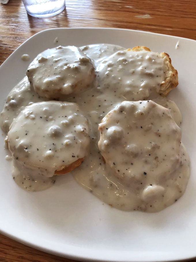 The biscuits and gravy—a masterclass in morning perfection where cloud-like biscuits surrender to peppery gravy. This isn't breakfast; it's edible therapy.