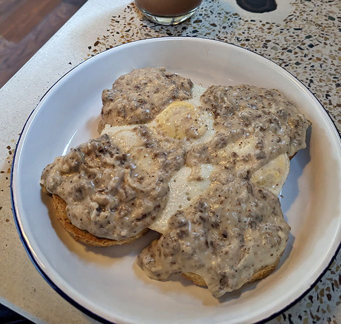 Southern comfort meets morning magic in this plate of biscuits drowning in creamy, peppery gravy heaven.