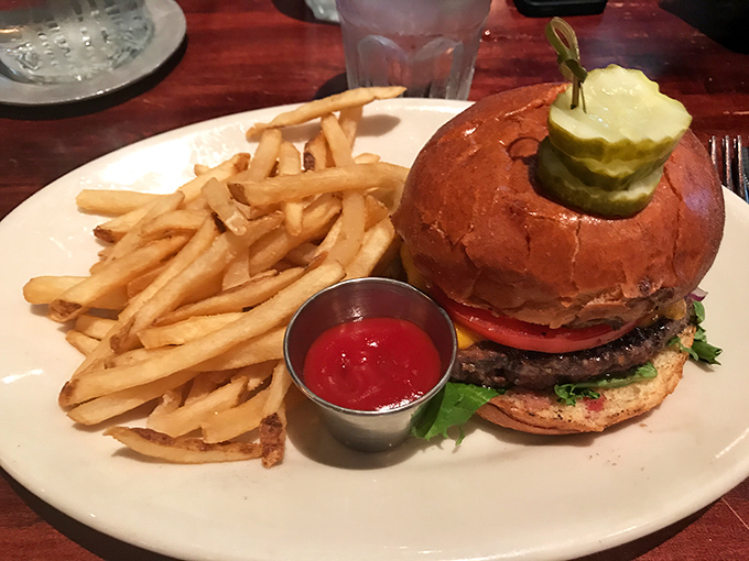 Behold the burger that makes salads question their life choices&mdash;a towering creation with crisp pickles standing guard over juicy beef perfection.