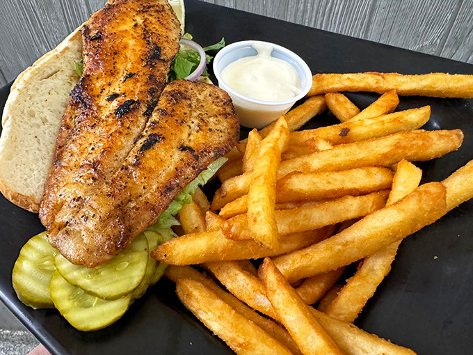 This blackened fish sandwich isn't just lunch&mdash;it's a vacation on a plate, with perfectly seasoned fish, crisp pickles, and fries that deserve their own fan club.