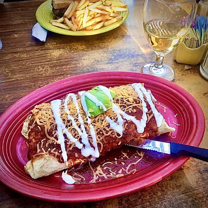 This breakfast burrito isn't just a meal, it's an architectural achievement—layers of flavor topped with melty cheese, sour cream, and fresh avocado.