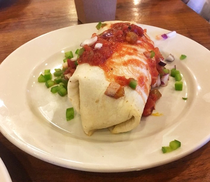 This breakfast burrito, topped with salsa and green onions, is what happens when breakfast decides to dress up and go dancing.