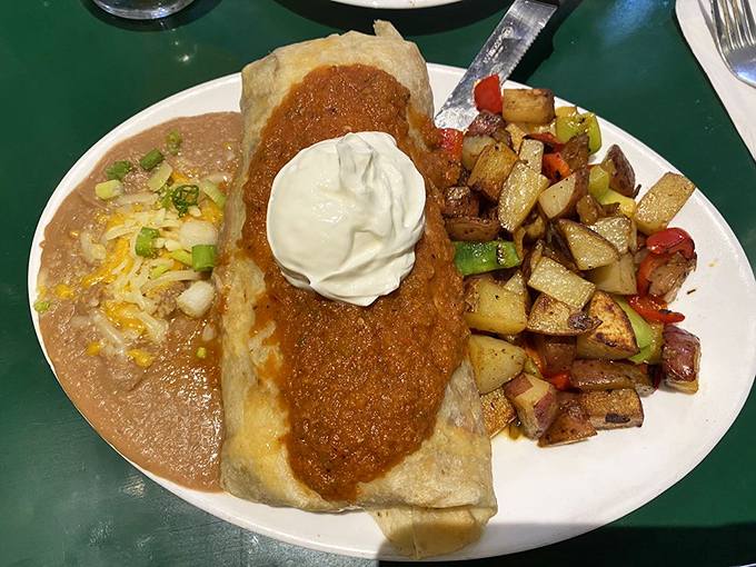 The breakfast burrito that solves all of life's problems. Smothered in chili, topped with sour cream, and flanked by home fries that deserve their own fan club.