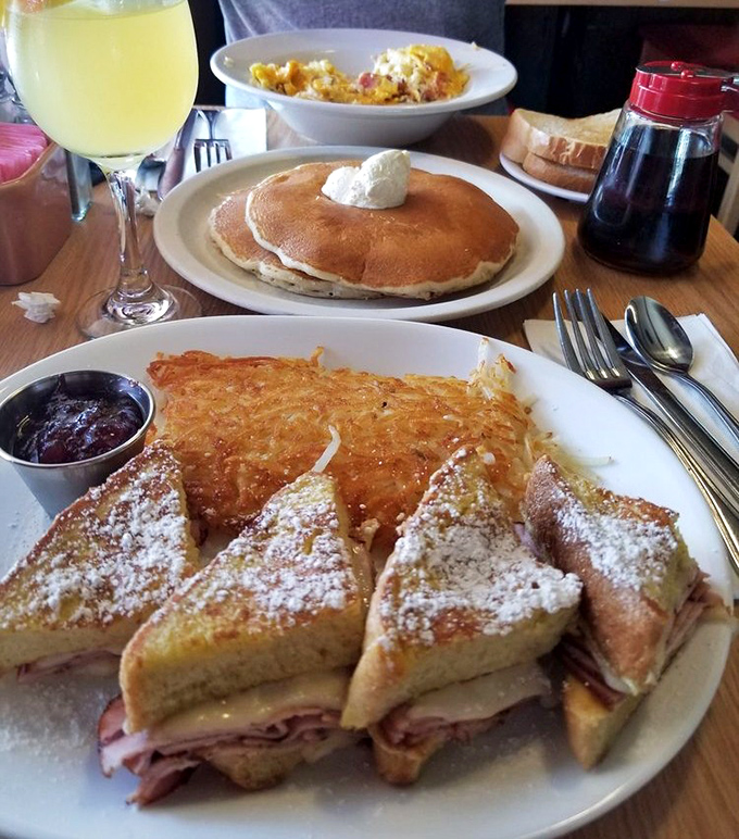 Breakfast perfection: golden French toast dusted with powdered sugar alongside crispy hash browns and a Monte Cristo that means business.