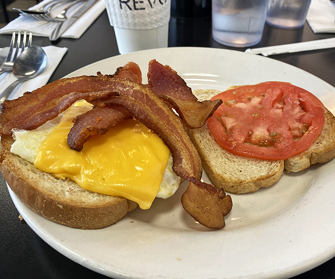 Breakfast architecture at its finest. The structural integrity of this sandwich is matched only by the harmony of its melted cheese and perfectly cooked egg.