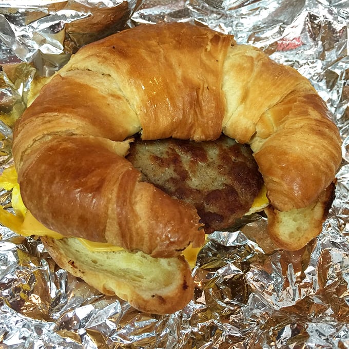 A breakfast sandwich worthy of poetry&mdash;golden croissant embracing eggs, cheese and sausage in a morning romance that never disappoints.
