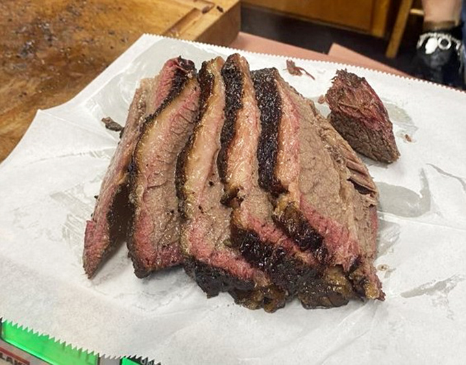 Brisket sliced to reveal that perfect smoke ring—the barbecue equivalent of a sunset gradient, where each layer tells a story of patience and expertise.
