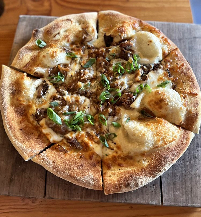 Pizza perfection achieved through wood-fire alchemy. The blistered crust and melty cheese islands make this pie worth every carb-laden bite.