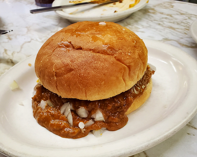 Chili burger nirvana! A soft bun barely containing the perfect ratio of beef, chili, and onions&mdash;a delicious mess worth every napkin you'll need.