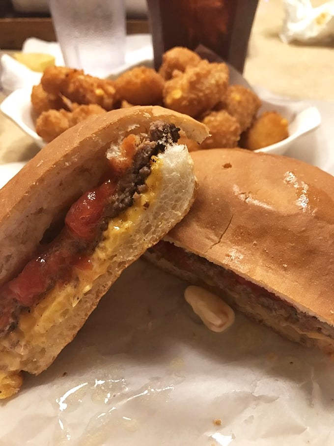 The cross-section reveals the truth: a perfectly charcoal-grilled patty on that distinctive hard roll, with cheese melting just right&mdash;burger engineering at its finest.