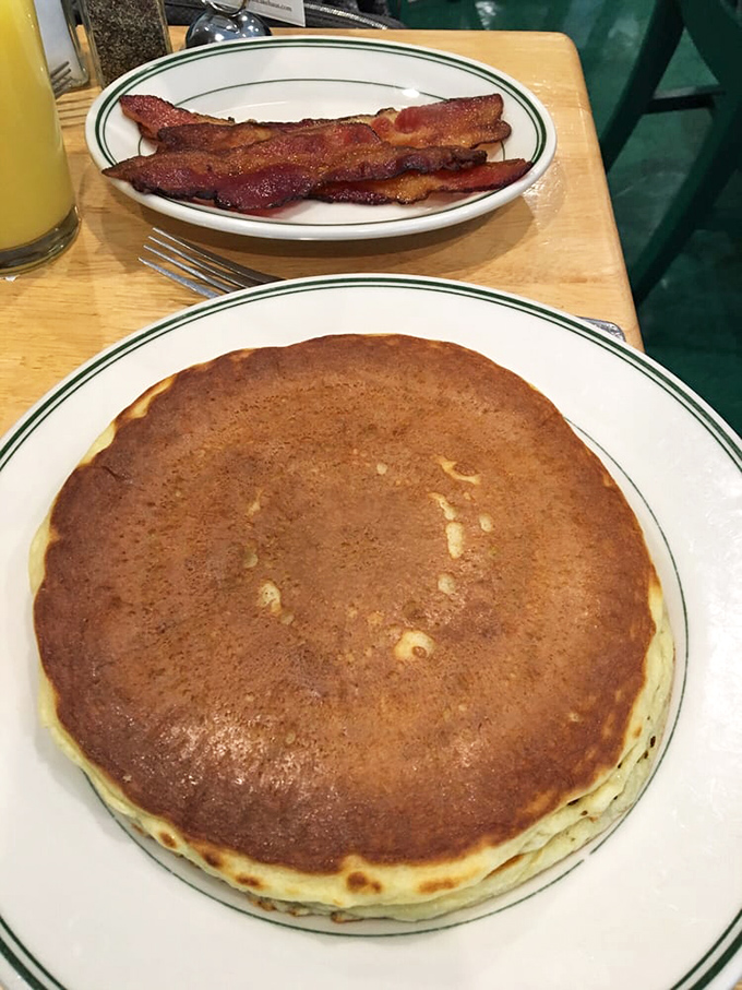 The pancake that launched a thousand return visits—golden, fluffy, and practically hovering above the plate with buttermilk magic.