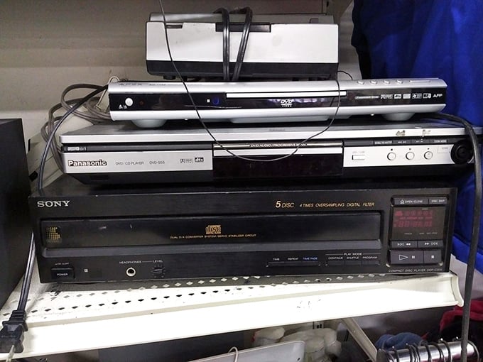 Technology's timeline sits on these shelves, where yesterday's cutting-edge electronics await collectors or those stubbornly clinging to physical media.