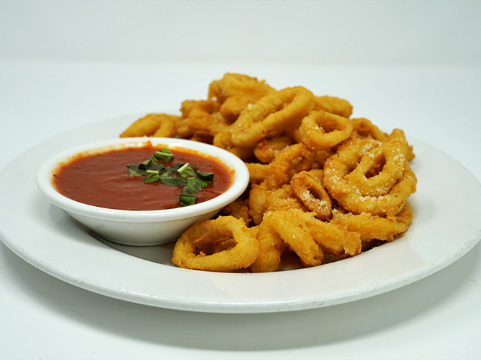 Crispy calamari that shatters like tiny dreams when you bite into them, with marinara sauce standing by for dunking duty.